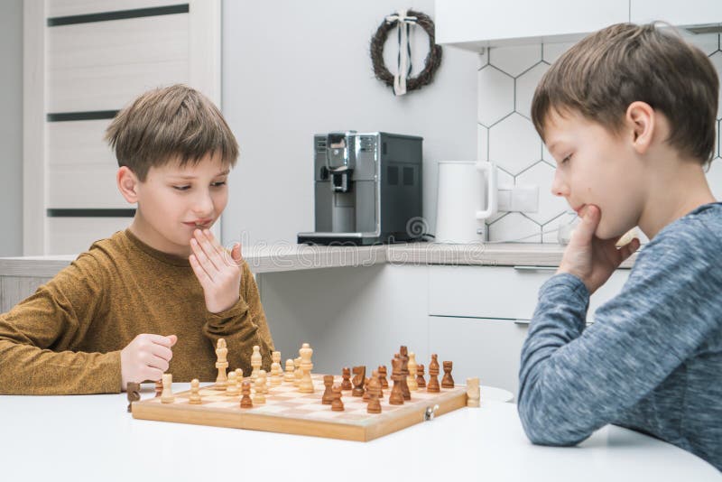Thinking Schoolboys Play Chess Sitting at Kitchen Table, Side View ...
