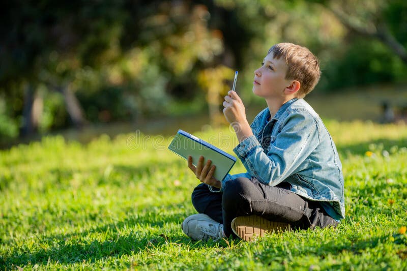 Thinking Student with a Textbook in His Hands is Sitting on a Green ...