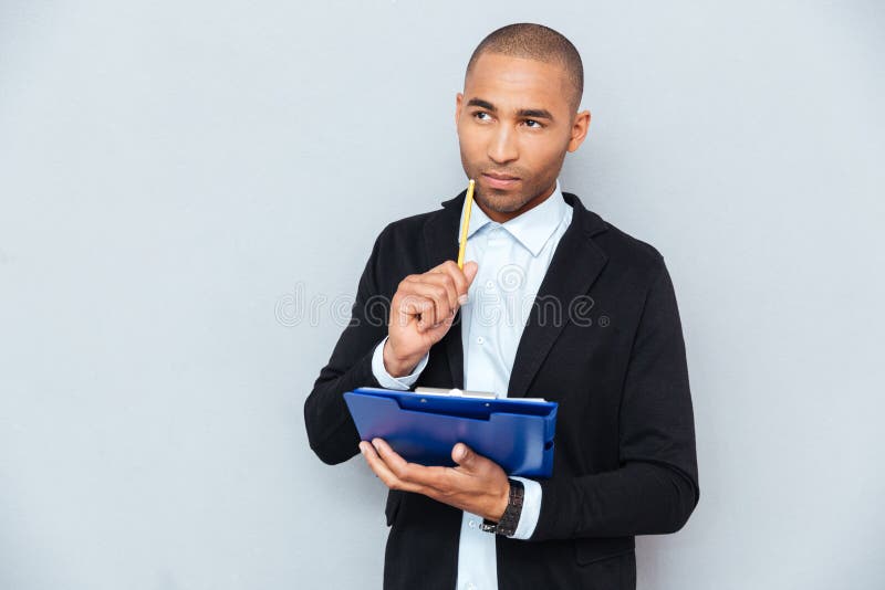 Thoughtful African Young Man Writing on Clipboard Stock Image - Image ...