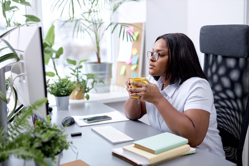 Thoughtful American Black Lady Drinking Tea Looking at Pc Computer ...