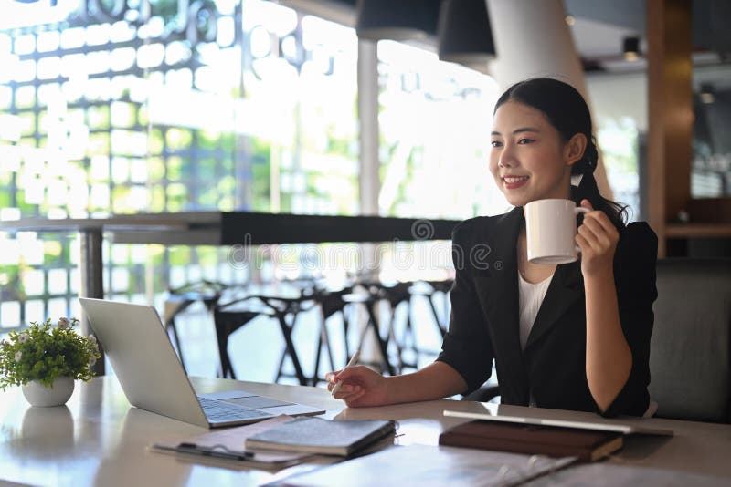 Thoughtful Businesswoman Drinking Coffee and Using Computer Laptop ...