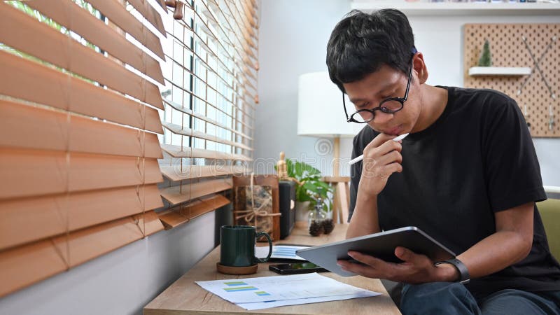 Asian Man Analyzing Data Stock Market on Digital Tablet at Home. Stock ...