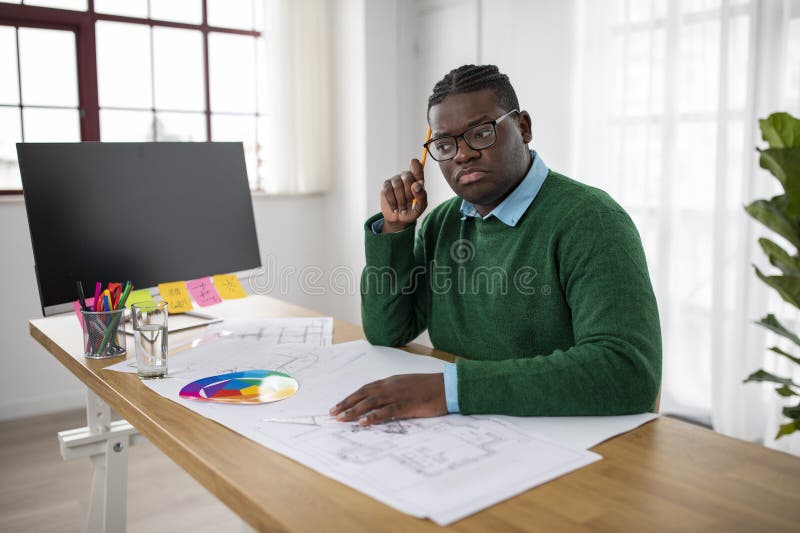 Thoughtful Black Engineer Man Working on Technical Drawing at Workplace ...