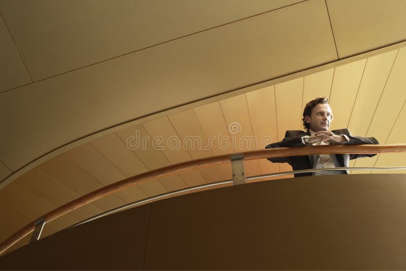 Thoughtful Businessman Leaning on Railing in Office Stock Image - Image ...