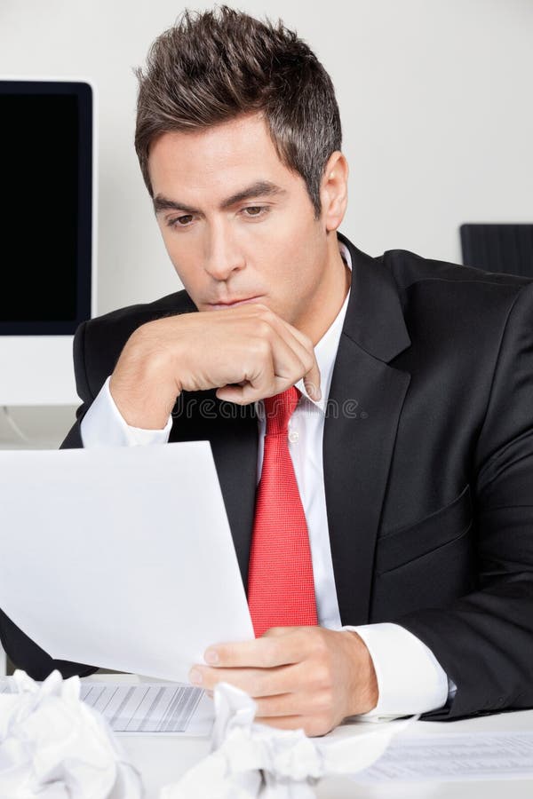 Thoughtful Businessman Reading Document in Office Stock Photo - Image ...