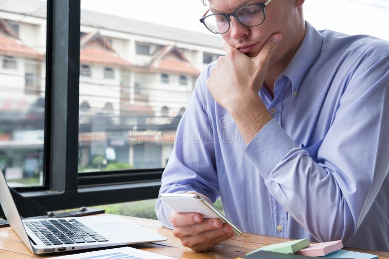Thoughtful Businessman Use Mobile Phone at Workplace. Man Texting ... Thoughtful Businessman Use Mobile Phone at Workplace. Man Texting ...