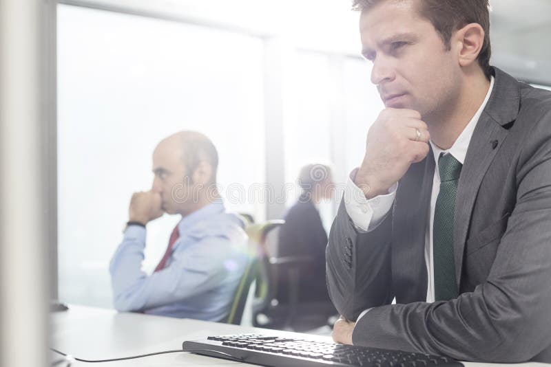 Thoughtful Businessman Working while Sitting at Desk in Modern Office ...