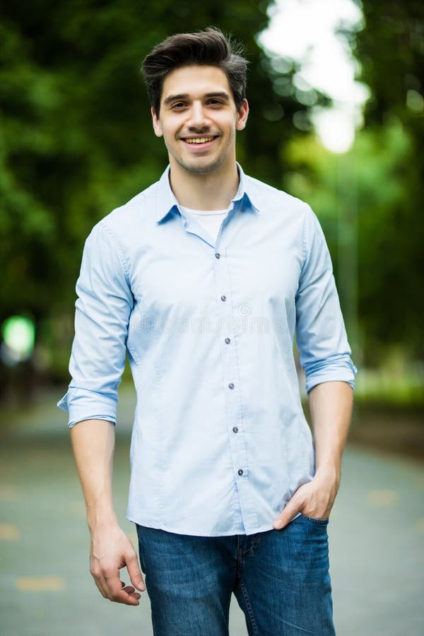 Thoughtful Casual Young Man Outdoors Looking Up and Smiling Stock Photo ...