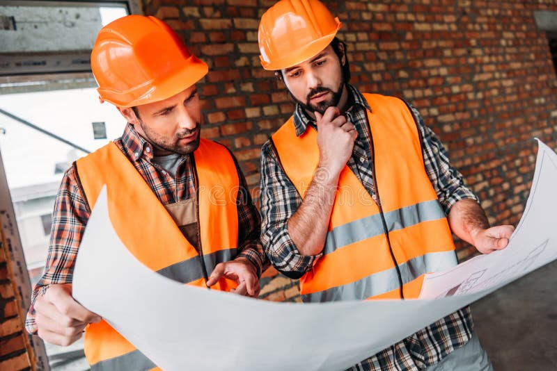 Thoughtful Confident Builders Working with Blueprint Stock Photo ...