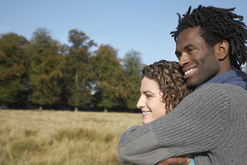 Thoughtful Couple Looking Away while Embracing in Field Stock Image ...