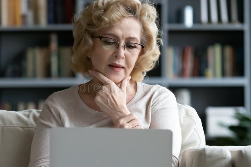 Thoughtful Elderly Woman Looking at Computer Screen. Stock Photo ...