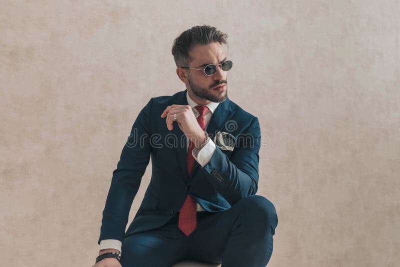 Thoughtful Elegant Man with Elbow on Knee Looking To Side and Thinking ...