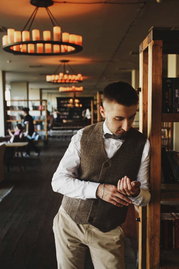 Thoughtful Man in Grey Waistcoat Poses in the Dark Library Stock Image ...