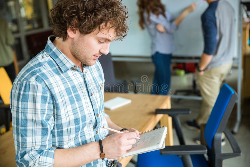 Thoughtful Man Making Notes in Notebook Creating Project with ...