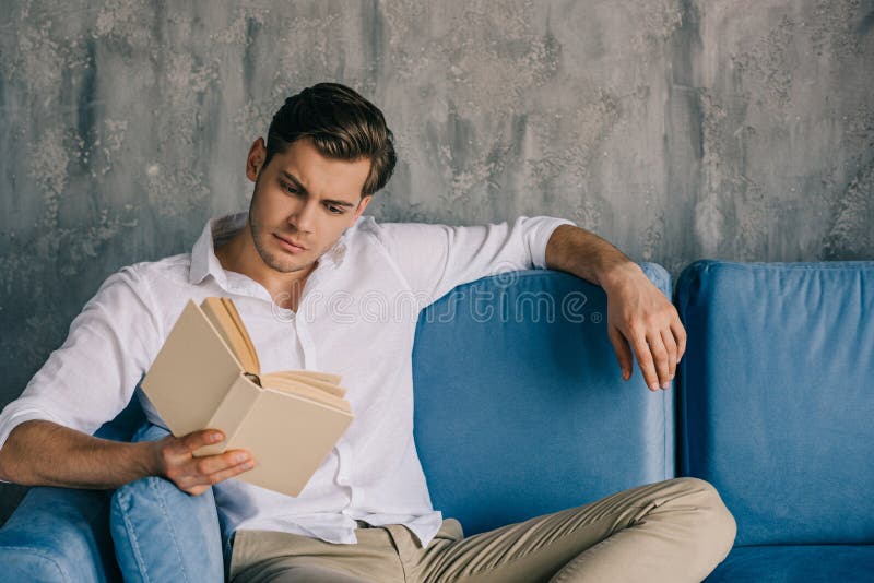Thoughtful Man Reading Book while Sitting Stock Photo - Image of style ...