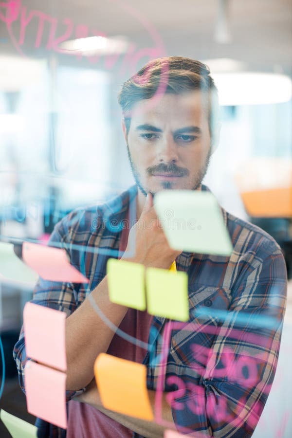 Thoughtful Man Reading Sticky Notes on the Glass Wall Stock Photo ...