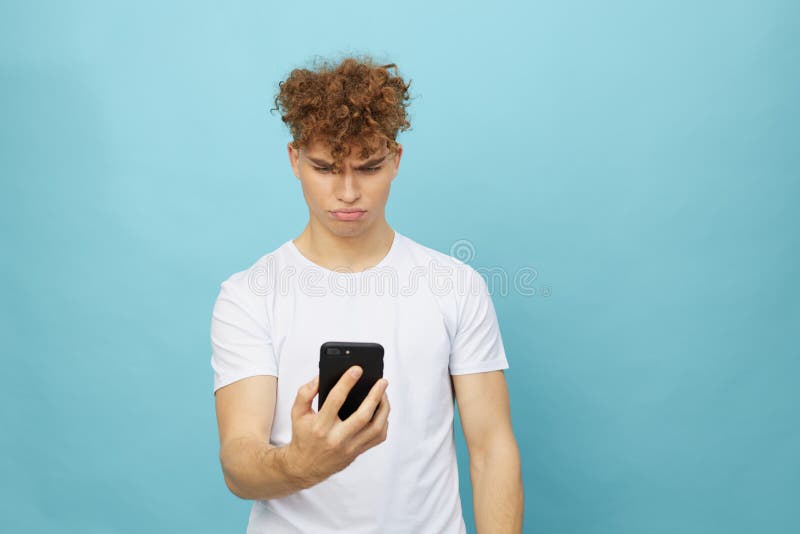 A Thoughtful Man is Standing on a Light Blue Background and Looking at ...