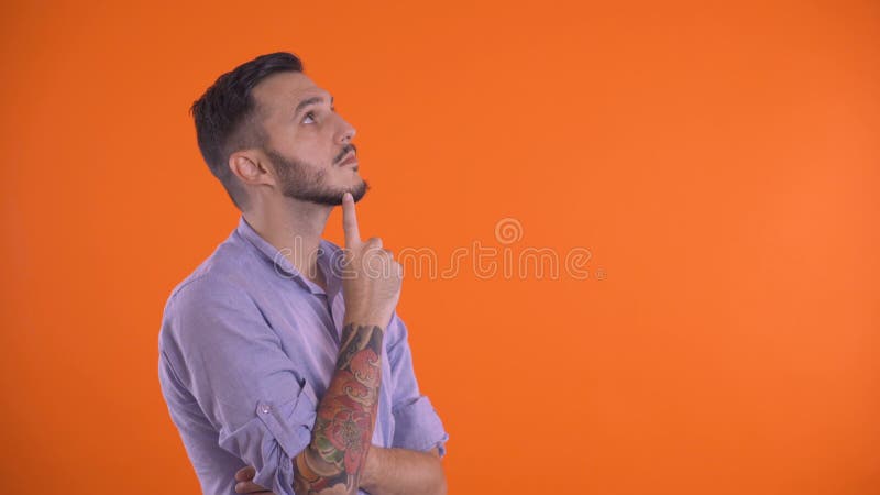 Thoughtful Man Thinking with Finger on Face, Isolated on Orange ...