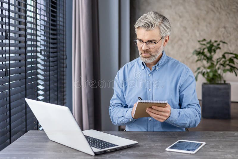 Thoughtful Mature Male with Grey Beard Looking at Portable Computer ...