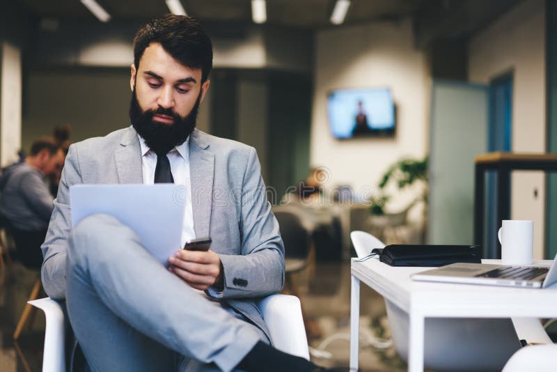 Serious Businessman Reading Report in Office Stock Image - Image of ...