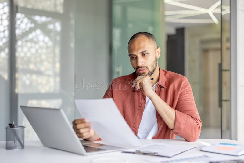 A Thoughtful Professional Examines Documents while Working at His ...