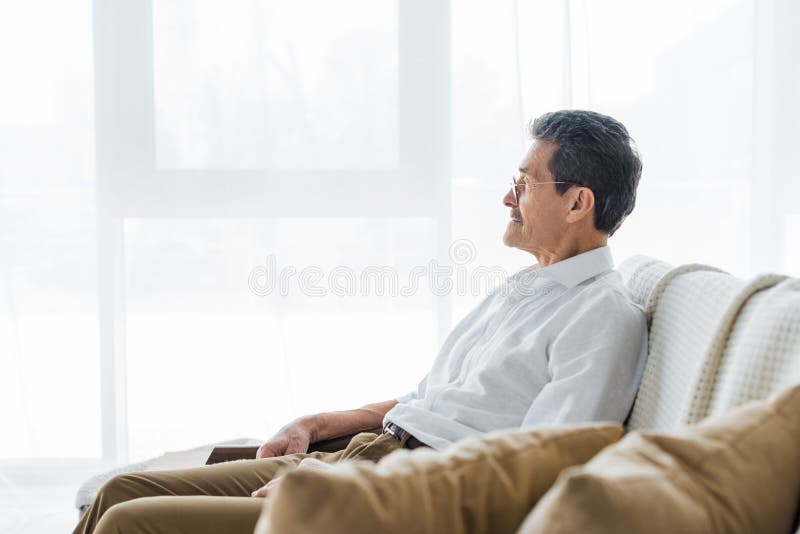 Thoughtful Senior Man Sitting on Sofa Stock Photo - Image of people ...