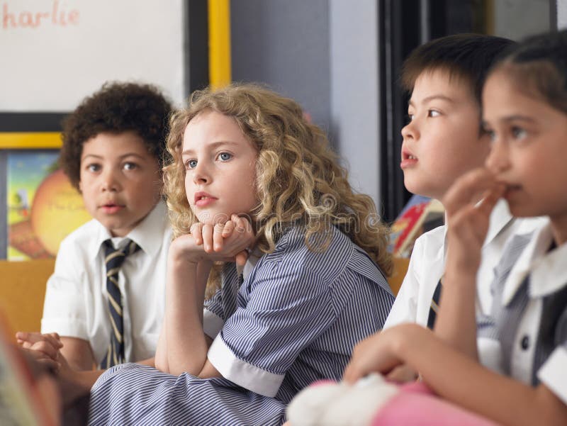 Thoughtful Students Sitting in Classroom Stock Photo - Image of indoors ...