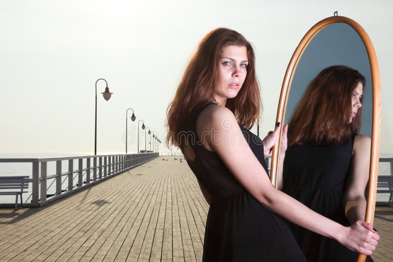 Thoughtful Woman Looks at the Reflection in Mirror Stock Image - Image ...