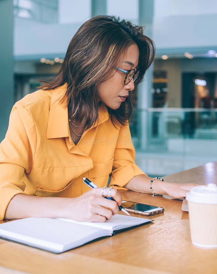 Thoughtful Woman Working on Laptop and Taking Notes Stock Image - Image ...