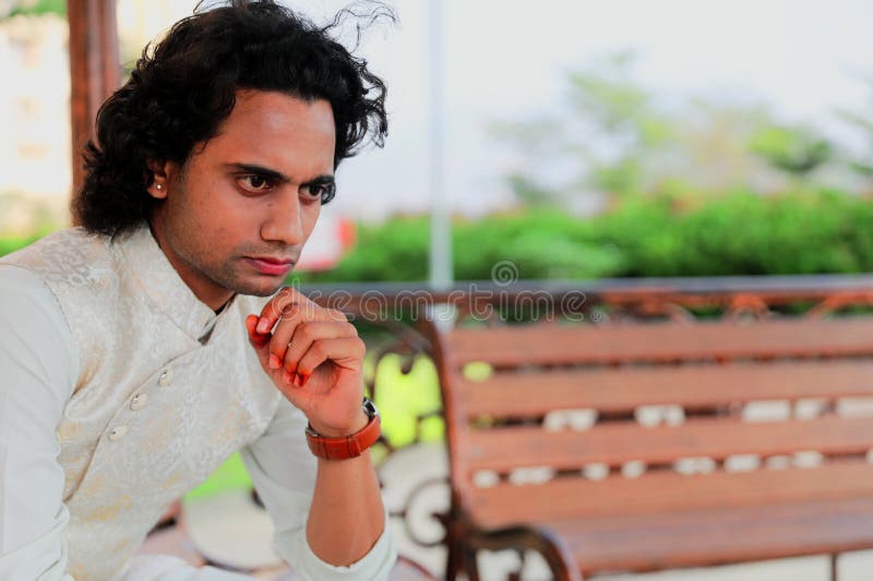 Thoughtful Yong Man in a Deep Thinking Process Sitting on the Bench in ...