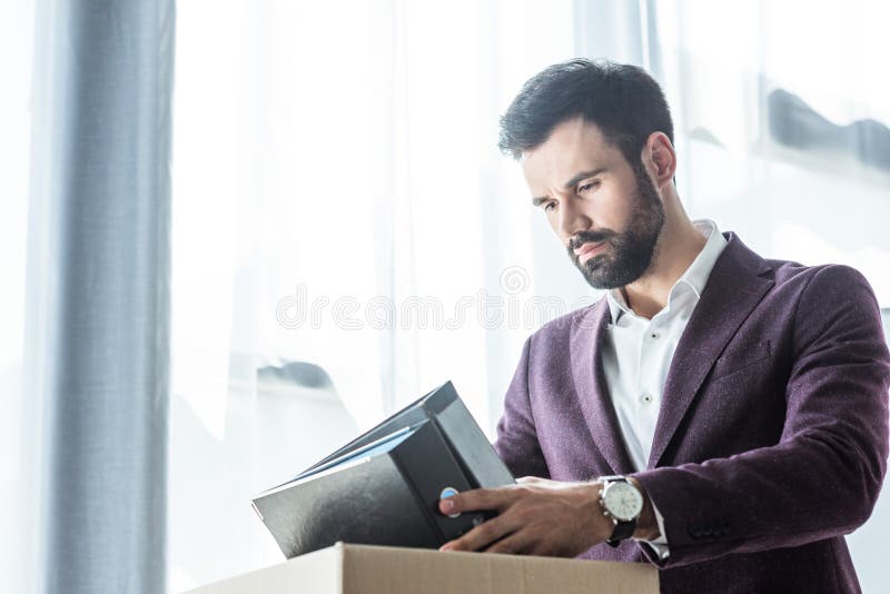Thoughtful Young Businessman Putting Books and Folders into Box after ...
