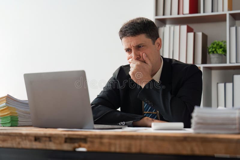 Thoughtful Young Businessman Staring at Laptop, Puzzled, Unsure Look ...