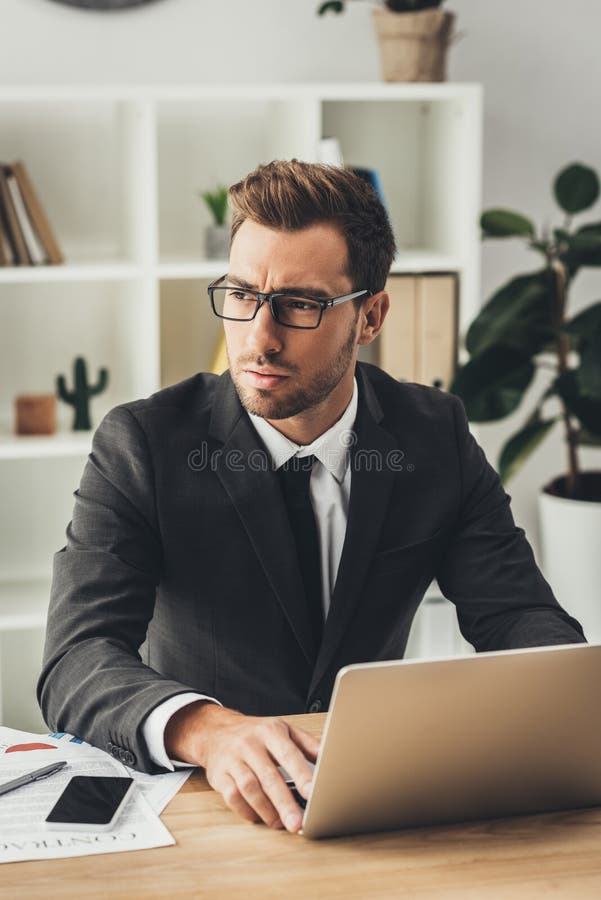 Thoughtful Young Businessman Working with Laptop Stock Photo - Image of ...