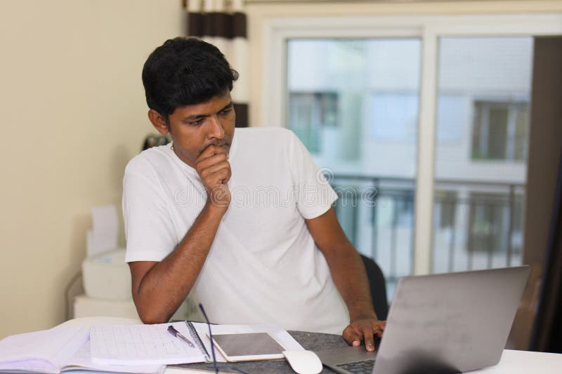 Thoughtful Young Indian Man Working on Laptop Computer at Home Stock ...