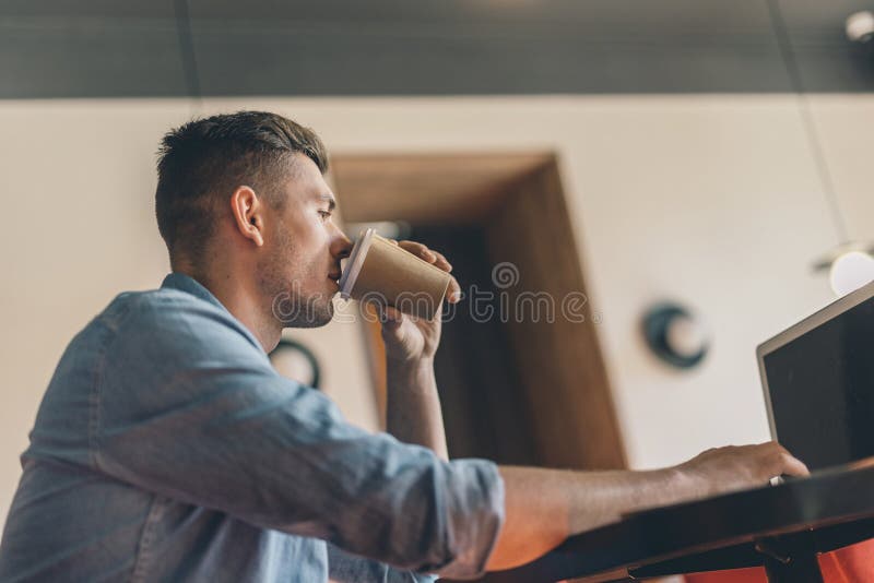 Thoughtful Young Man Drinking Coffee and Looking at the Screen Stock ... Thoughtful Young Man Drinking Coffee and Looking at the Screen Stock ...