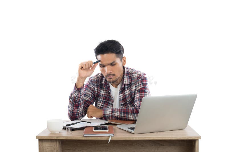Thoughtful Young Man Holding Pen Looking at Notepad while Sitting at ...