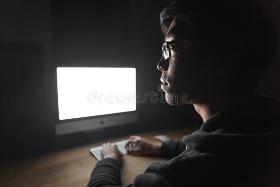Thoughtful Young Man Using Blank Screen Computer in Dark Room Stock ...