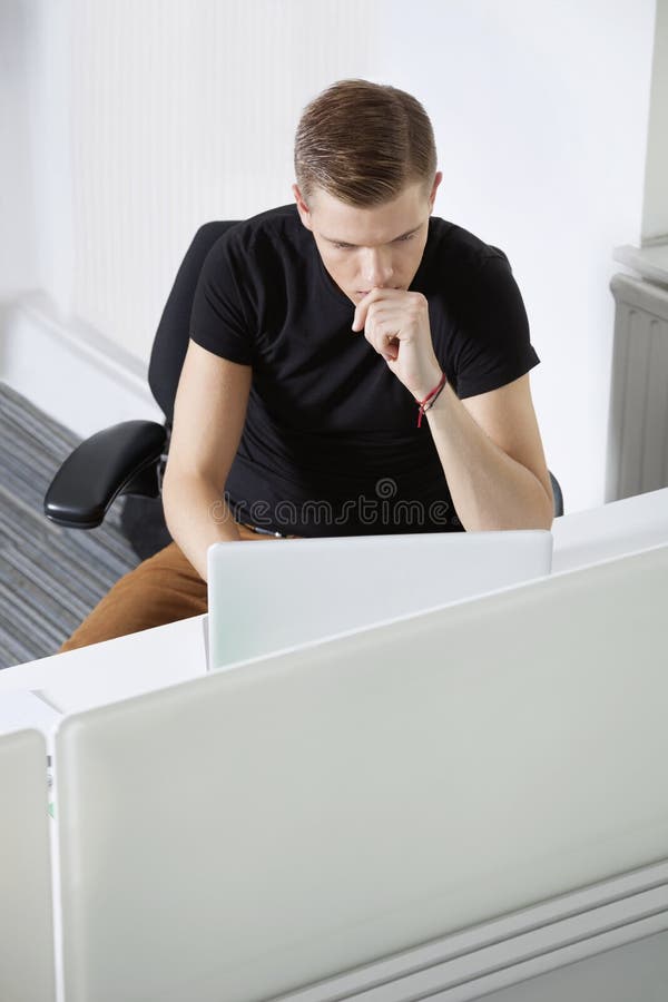 Thoughtful Young Man Working at Desk in Office Stock Image - Image of ...