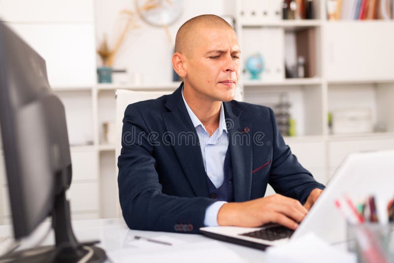 Thoughtful Young Man Working with Laptop and Documents Stock Image ...