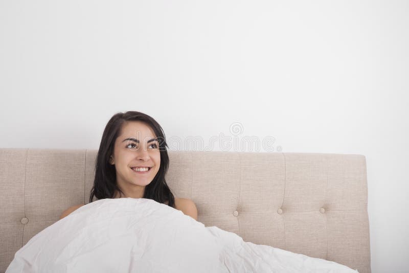 Thoughtful Young Woman Smiling in Bed Stock Photo - Image of ...