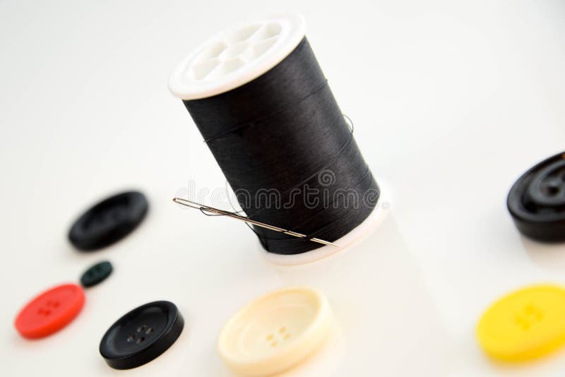 Threaded Needle, Black Thread Spool and Buttons Stock Photo - Image of ...