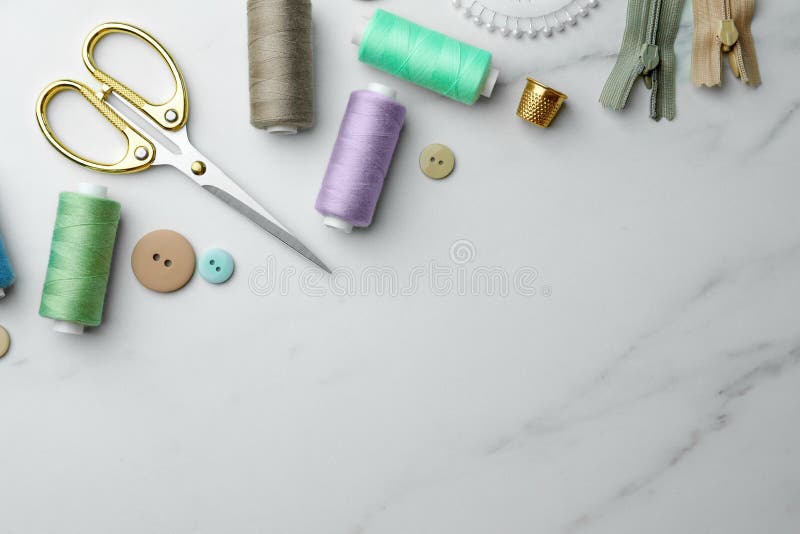 Threads and Other Sewing Supplies on White Marble Table, Flat Lay ...