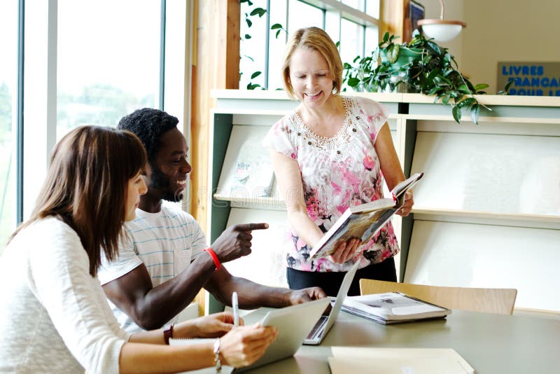 Three Adults Comparing Notes Stock Photo - Image of smiling, knowledge ...