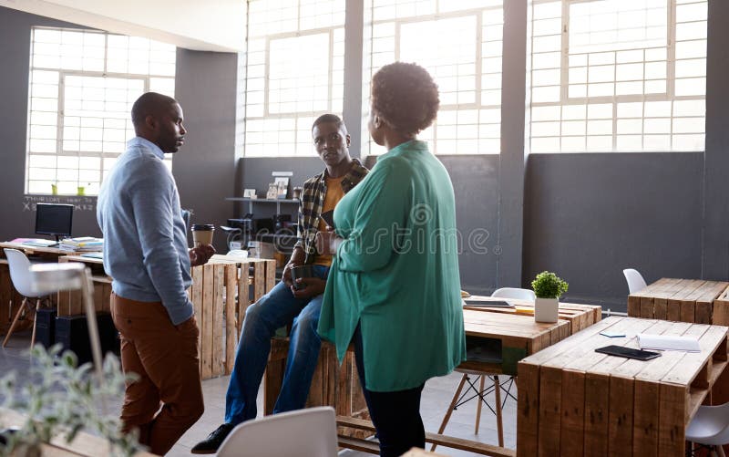 Three Work Colleagues Talking Business Together in an Office Stock ...