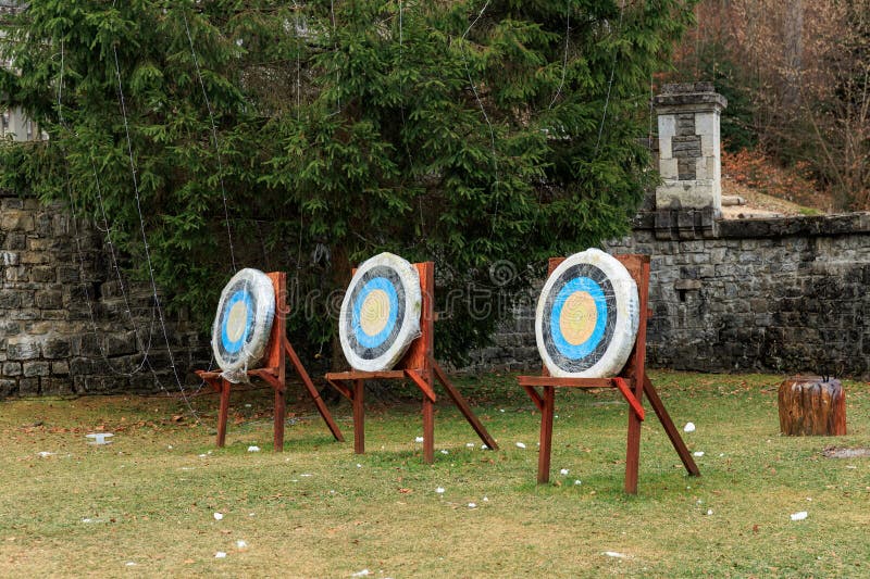 Three Archery Targets in a Row Outdoors on a Grassy Field with Stone ...