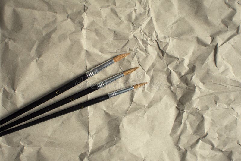 Three Artistic Brushes on Crumbled Paper Stock Photo - Image of ...