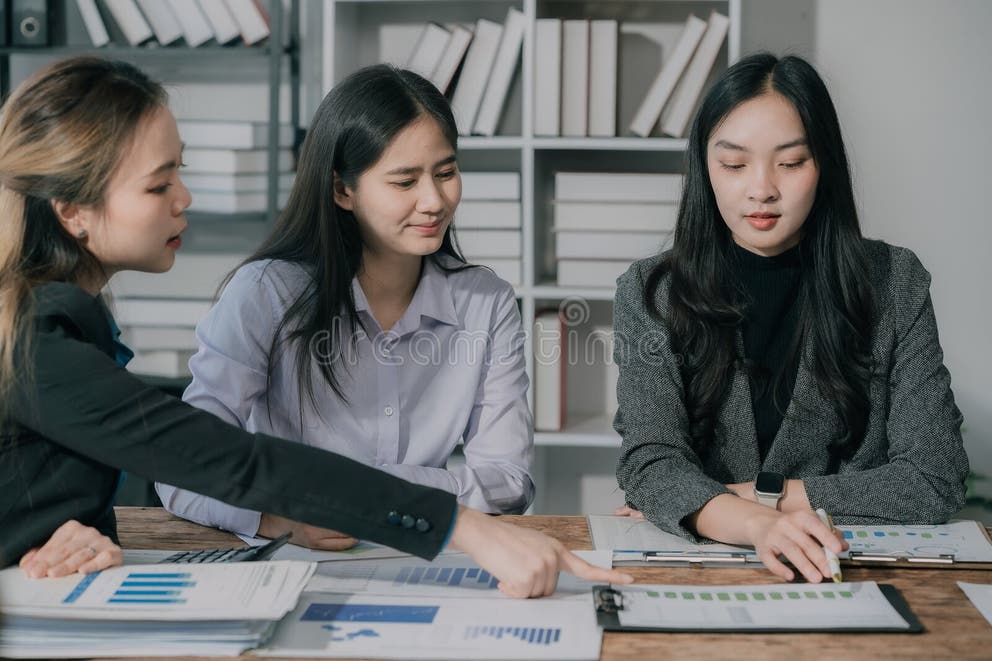 Three Asian Business Women Making Money from Document Graphs, Analyzing ...