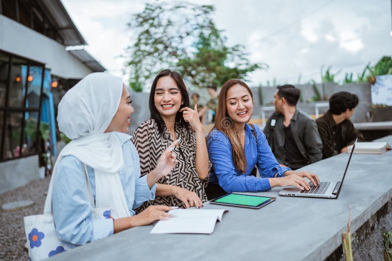 Three Asian Female Students Chat while Working on a Project Together ...