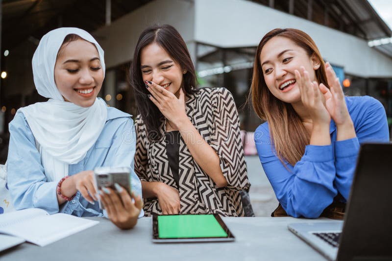 Three Asian Female Students Sit Using a Cell Phone, Tablet and Laptop ...