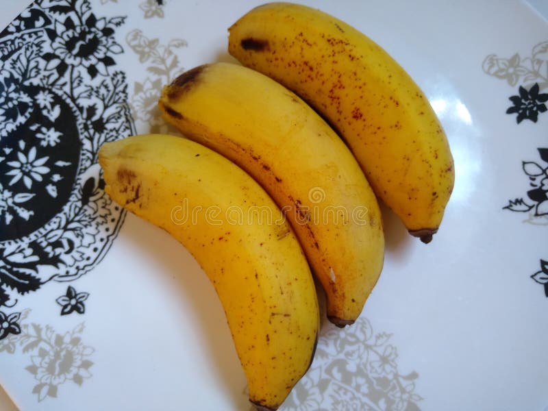 Three bananas on a plate stock photo. Image of fruits - 149597656